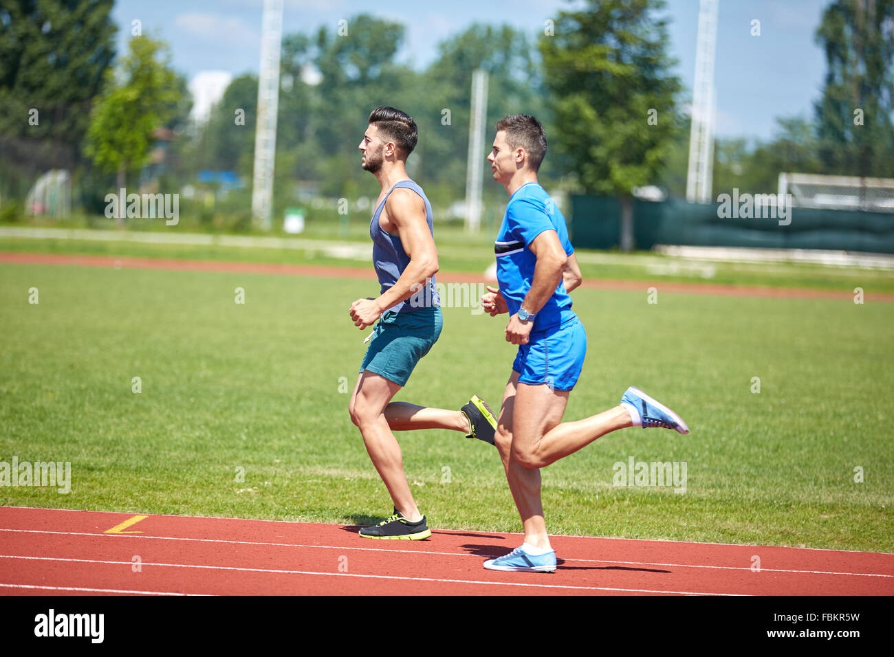 Two athletes friends running on a stadium track Stock Photo - Alamy