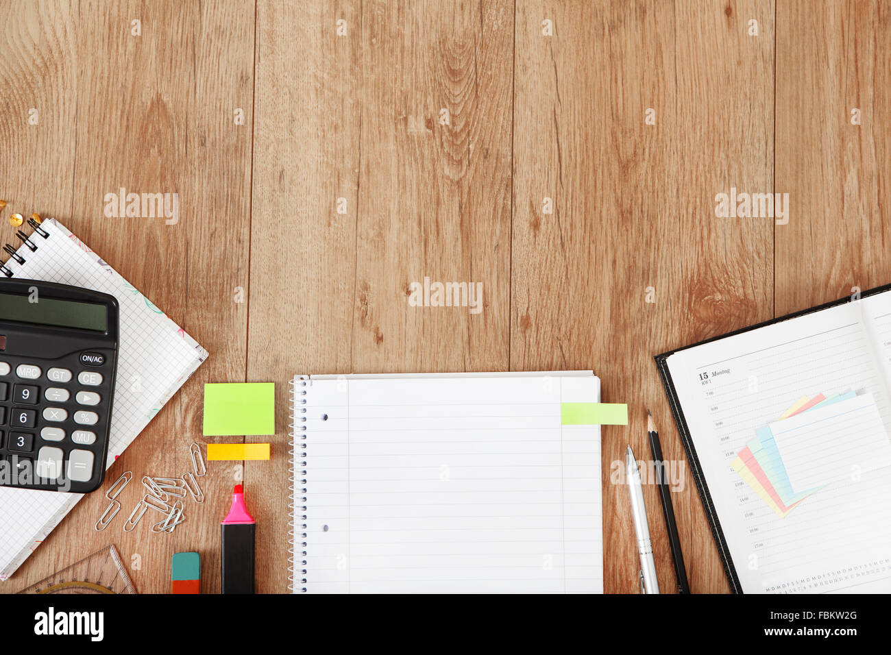 a calendar and a notepad lying on a desk with pencils and calculator ...