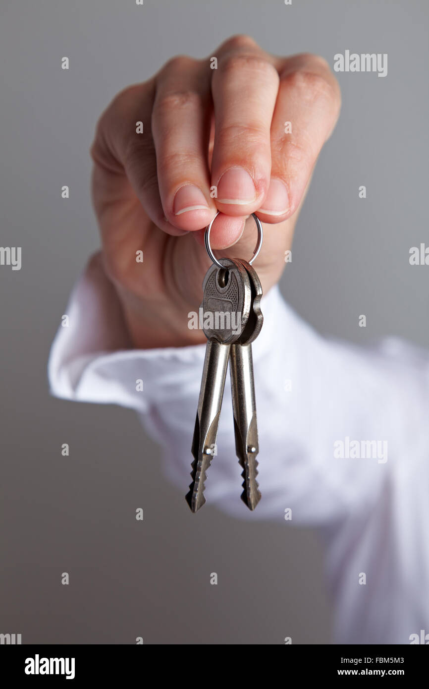 Hand holding two house keys on a key chain Stock Photo - Alamy