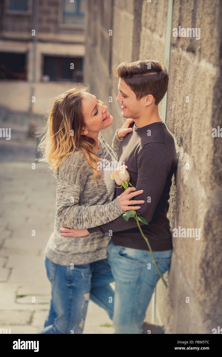 Candid Portrait Of Beautiful European Couple With Rose In Love Kissing