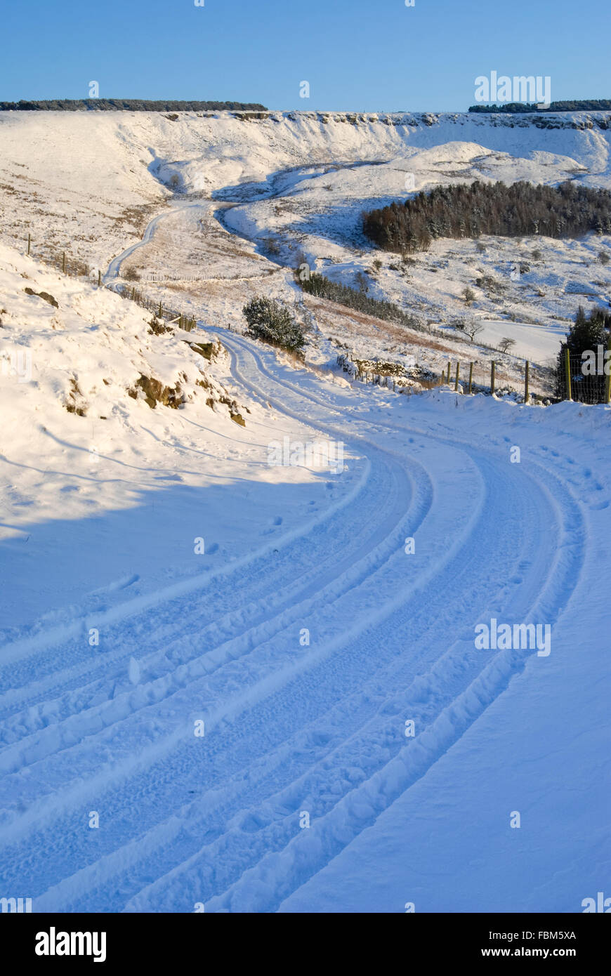A farm track leading through a snowy and hilly landscape in Northern ...