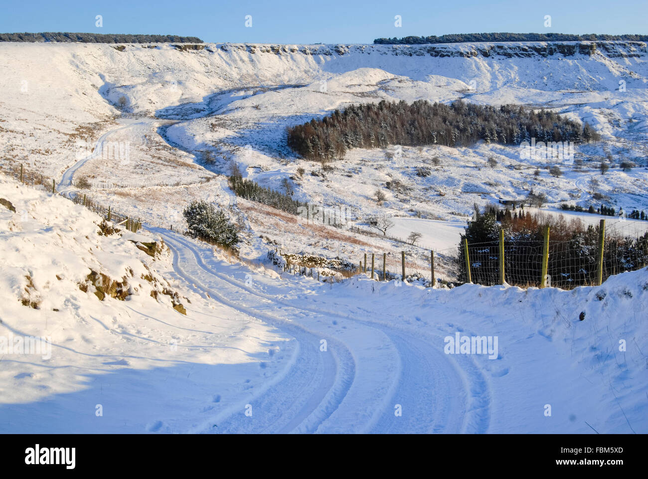 A farm track leading through a snowy and hilly landscape in Northern ...