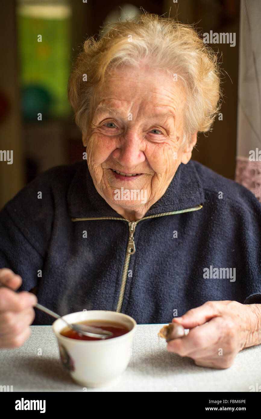 Elderly woman drinking tea Stock Photo - Alamy