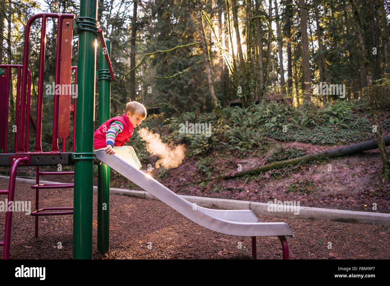 Boy on a slide in park Stock Photo - Alamy