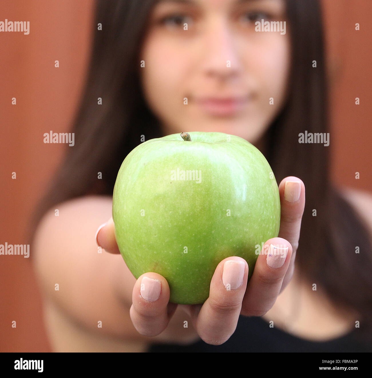 Young woman holding an apple Stock Photo - Alamy