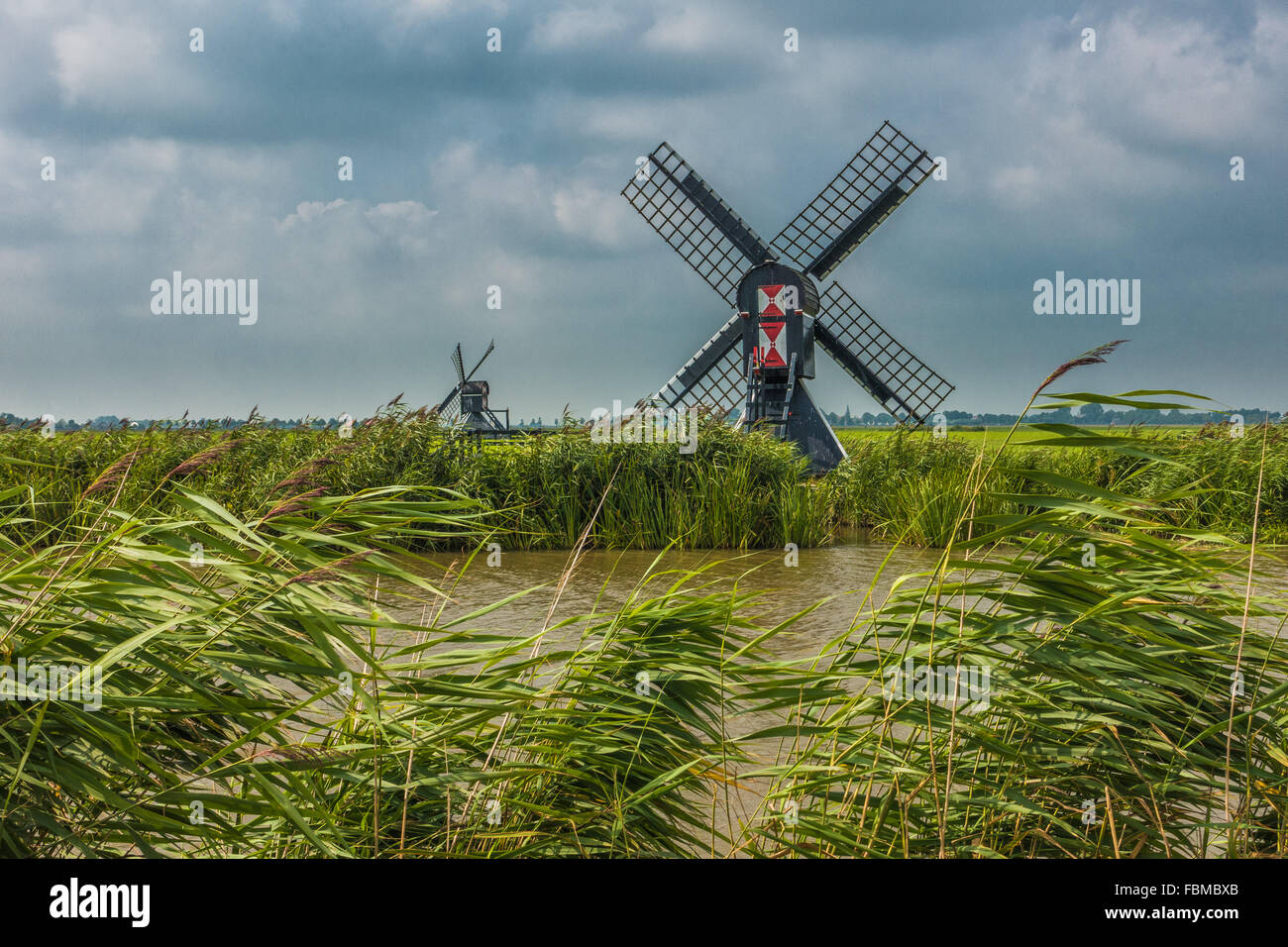 Windmills along riverbank, Friesland, Netherlands Stock Photo - Alamy