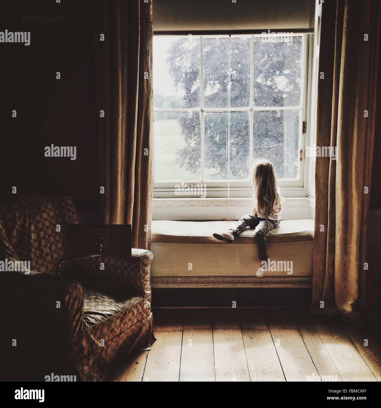 Girl looking out of a window Stock Photo - Alamy