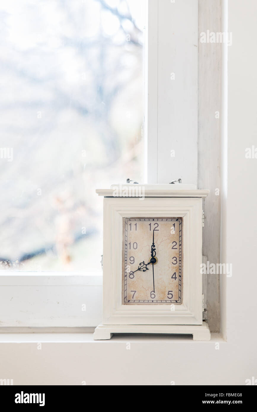 Clock on window sill Stock Photo - Alamy