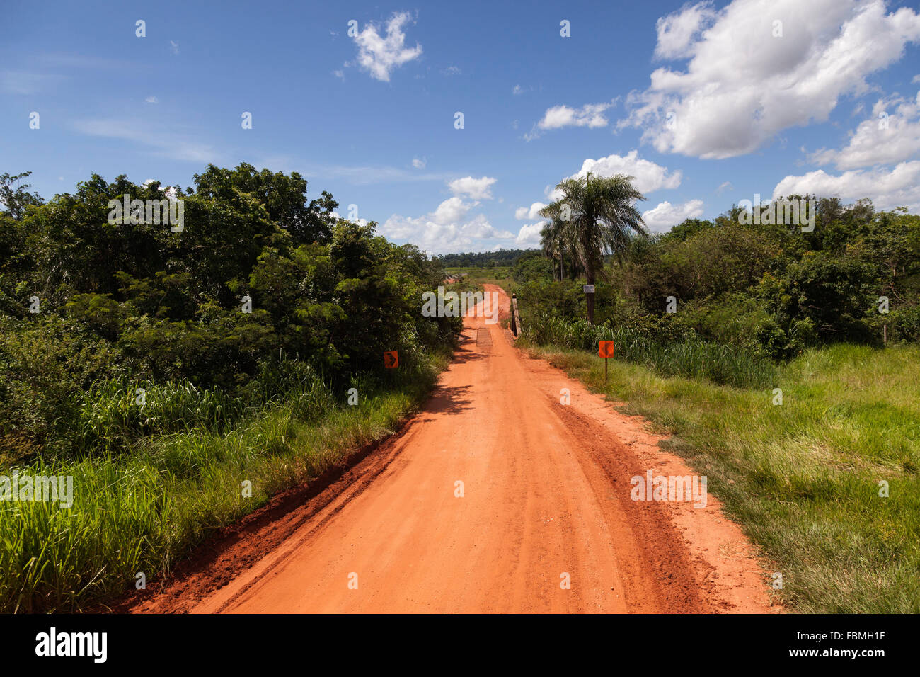 Brazilian landscape with a long country road showing red earth, near ...