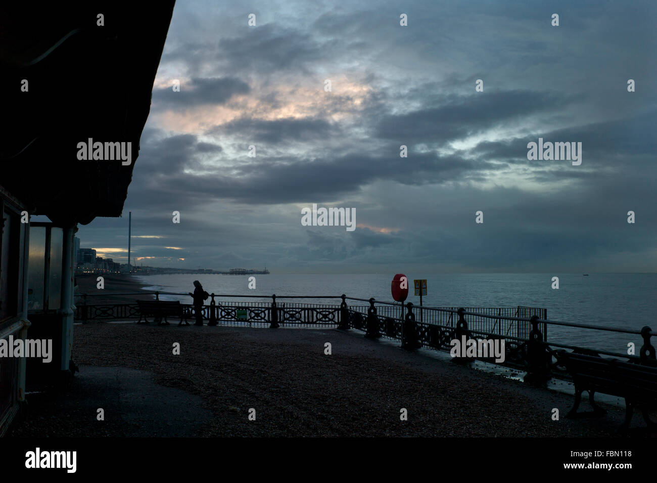 Silhouette of woman checking mobile phone at sunrise, seaside, dramatic ...