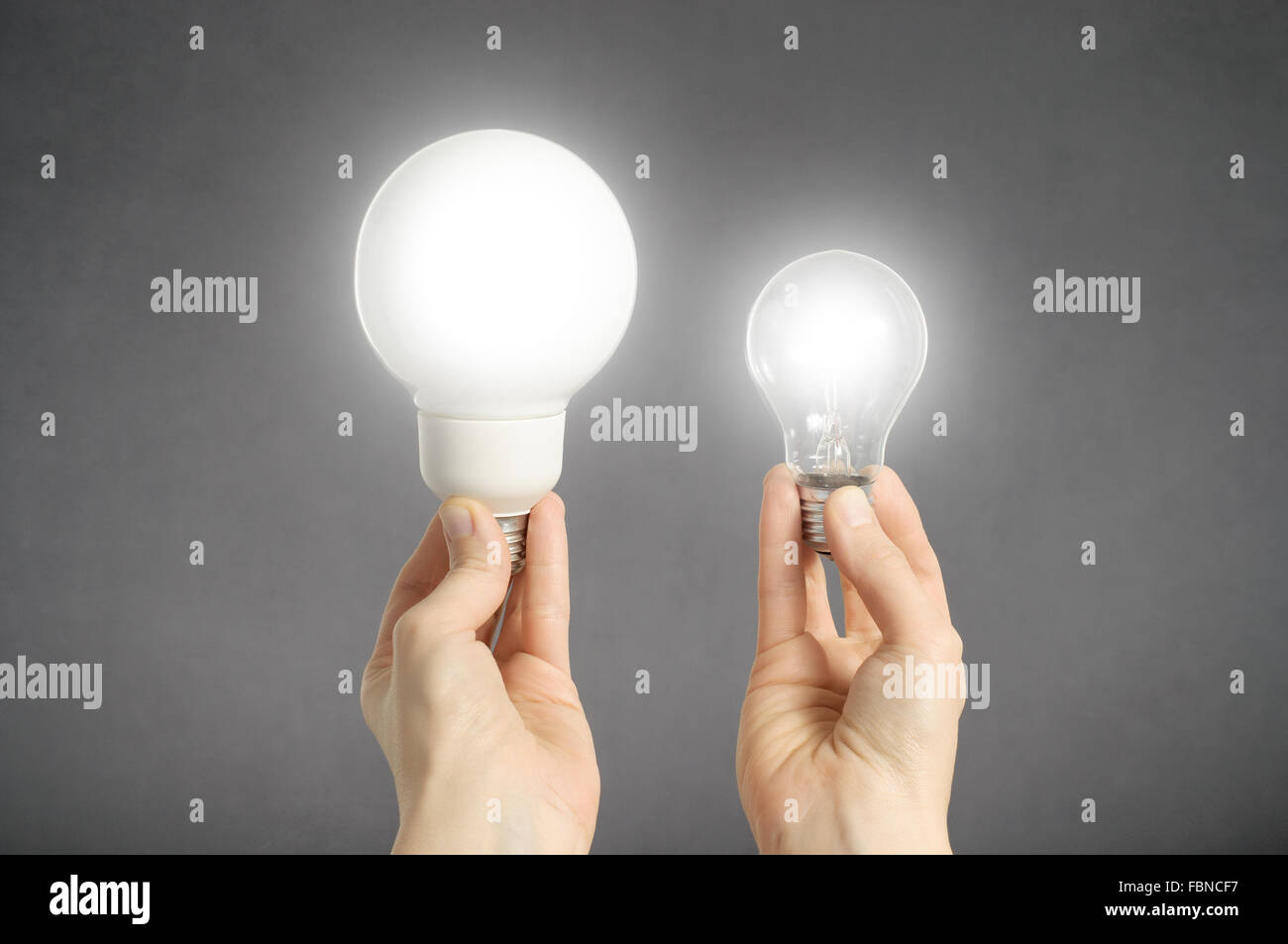 Hands holding two glowing light bulbs Stock Photo - Alamy
