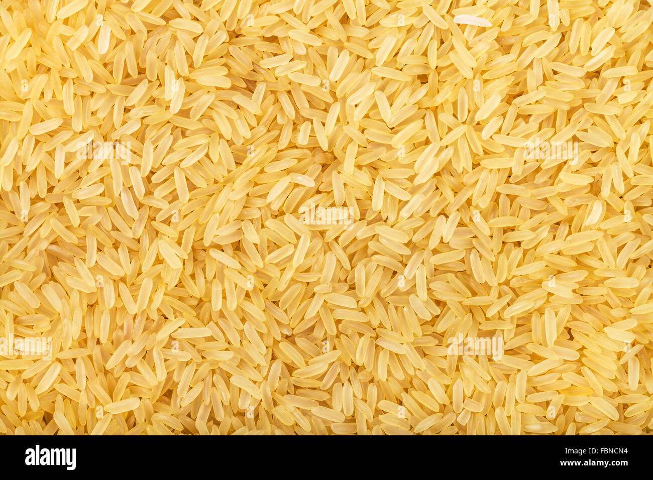 food background - yellow parboiled long-grain Indica rice Stock Photo ...