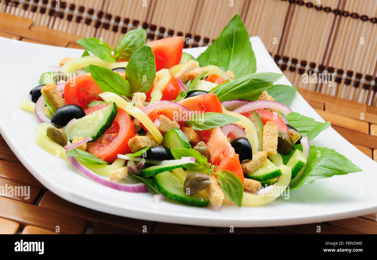 Fresh vegetable salad with basil, capers, olives, marinated with ...