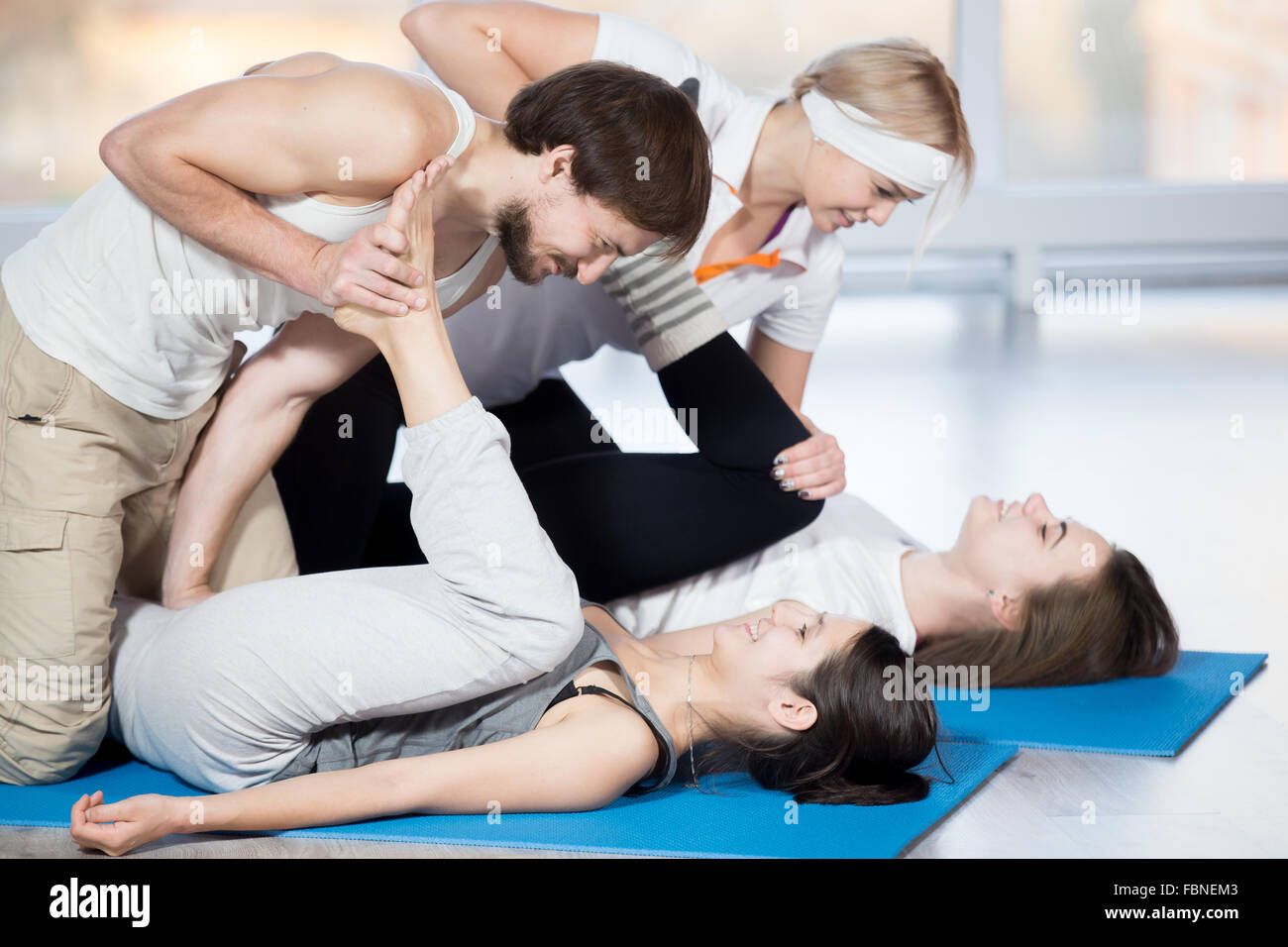 Fitness, stretching practice, group of four beautiful cheerful fit ...
