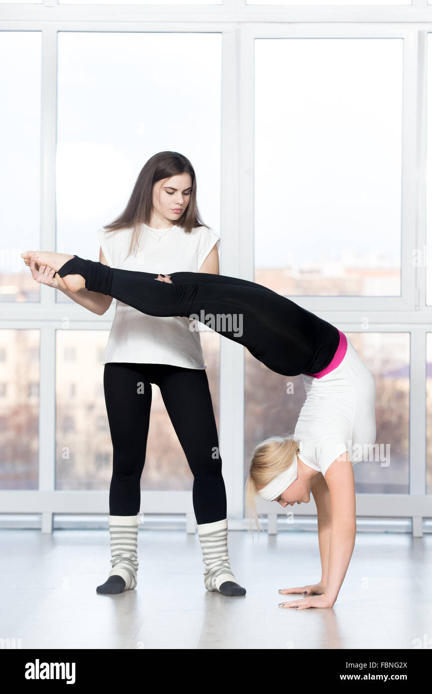 Fitness practice, partner helping young beautiful student female to do ...