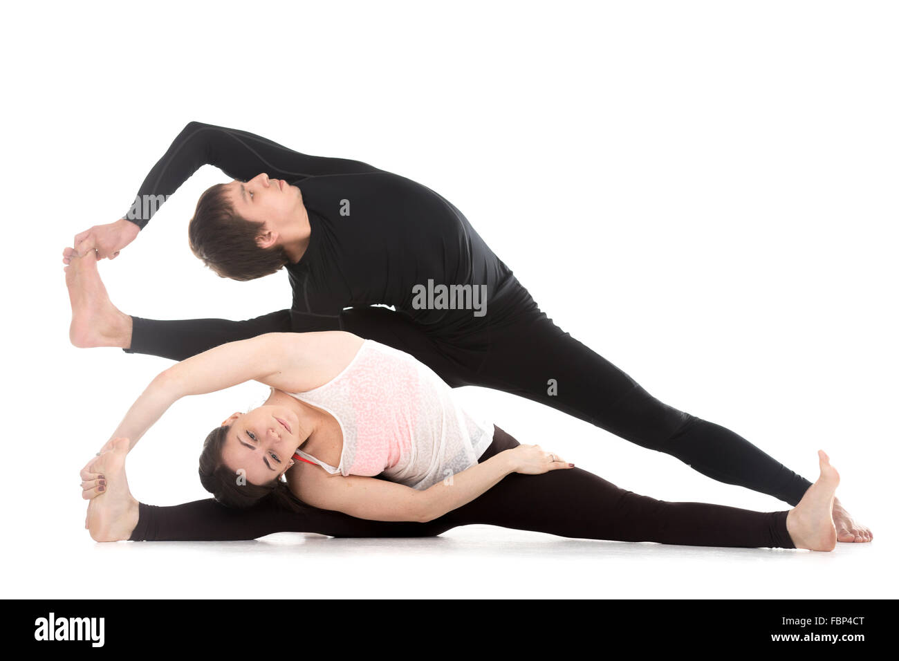 Sporty young couple on white background doing different side bend ...