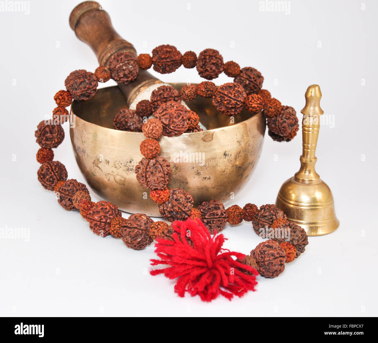 Tibetan Singing Bowl with beads and metal bell on a white background ...