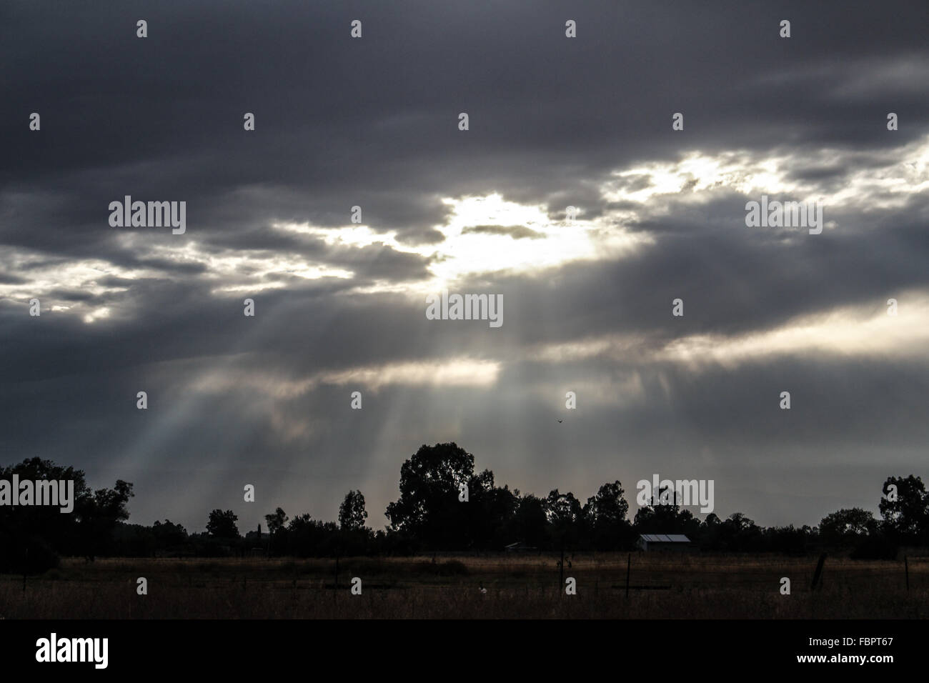 Sun rays breaking through clouds across the plains Stock Photo - Alamy