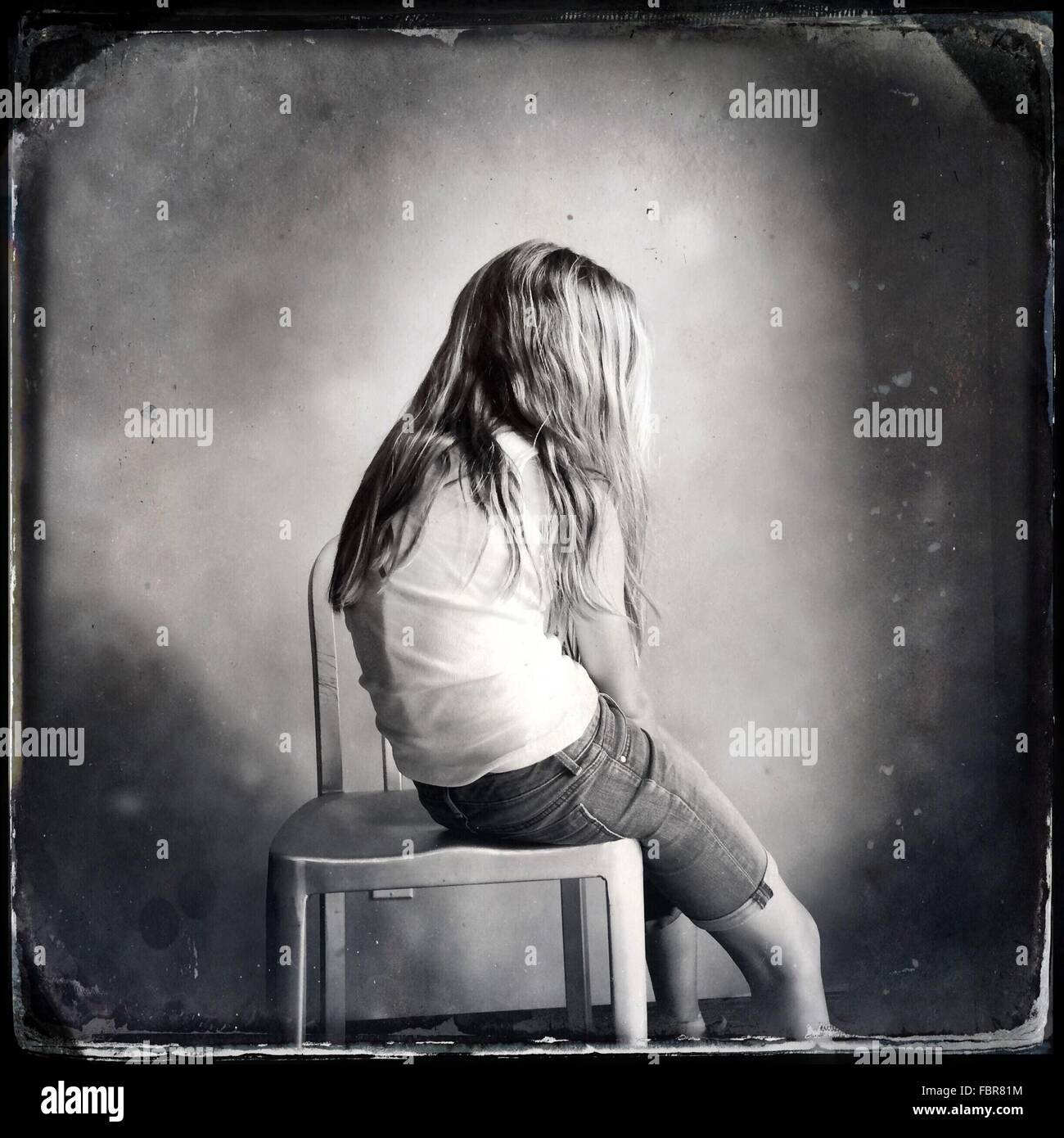 Rear View Of Girl Sitting On Chair Stock Photo - Alamy