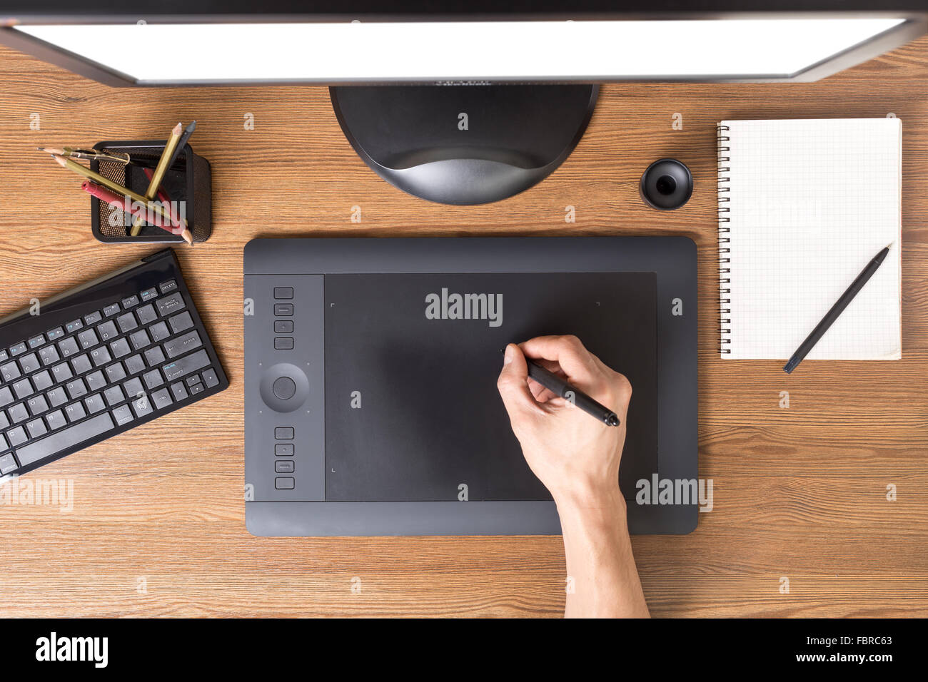 Designer using graphic tablet in the office. Top view workplace with ...