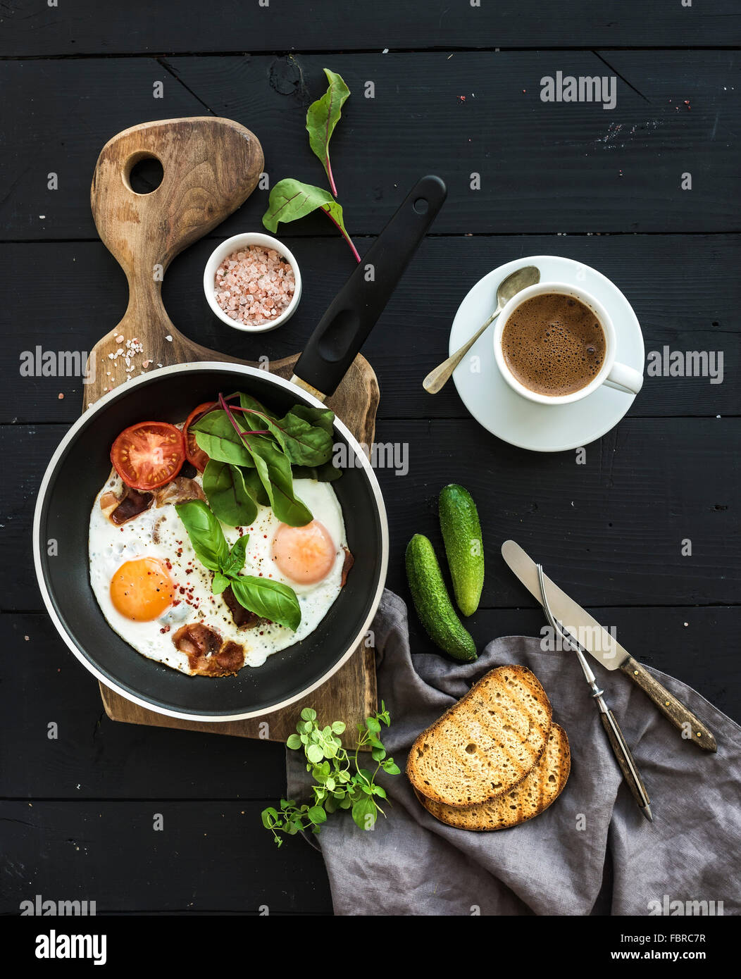 Breakfast set. Pan of fried eggs, bacon, tomatoes with bread, mangold ...