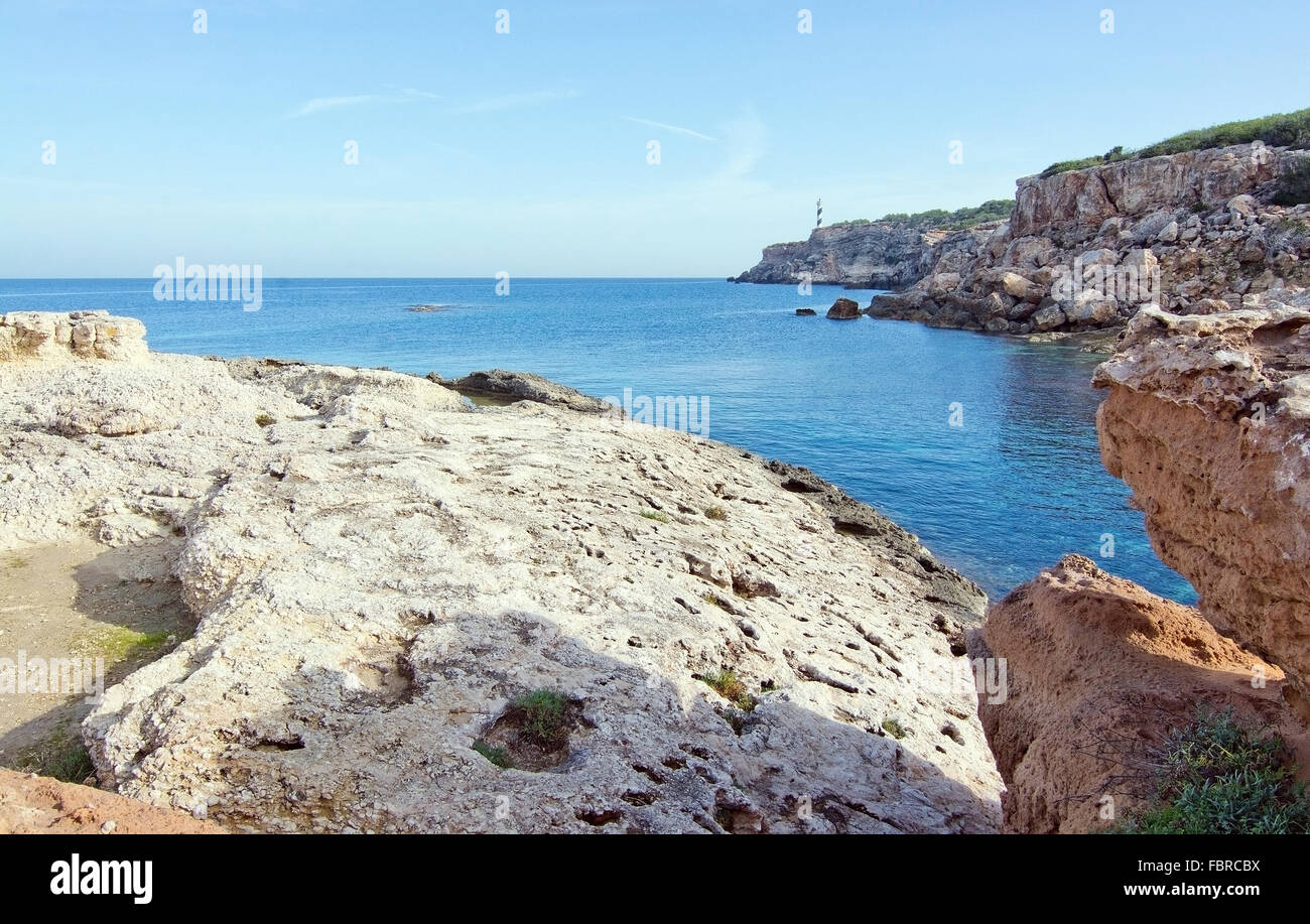 Seaside rocky landscape with red limestone cliff in Portinatx, Ibiza ...