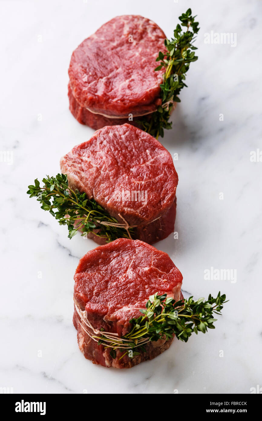 Raw fresh marbled meat Steak filet mignon and thyme on white marble ...