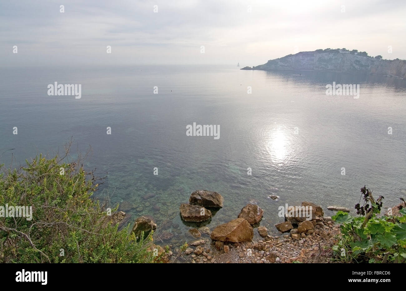 Natural seaside landscape with red rocks, clear water and sun ...