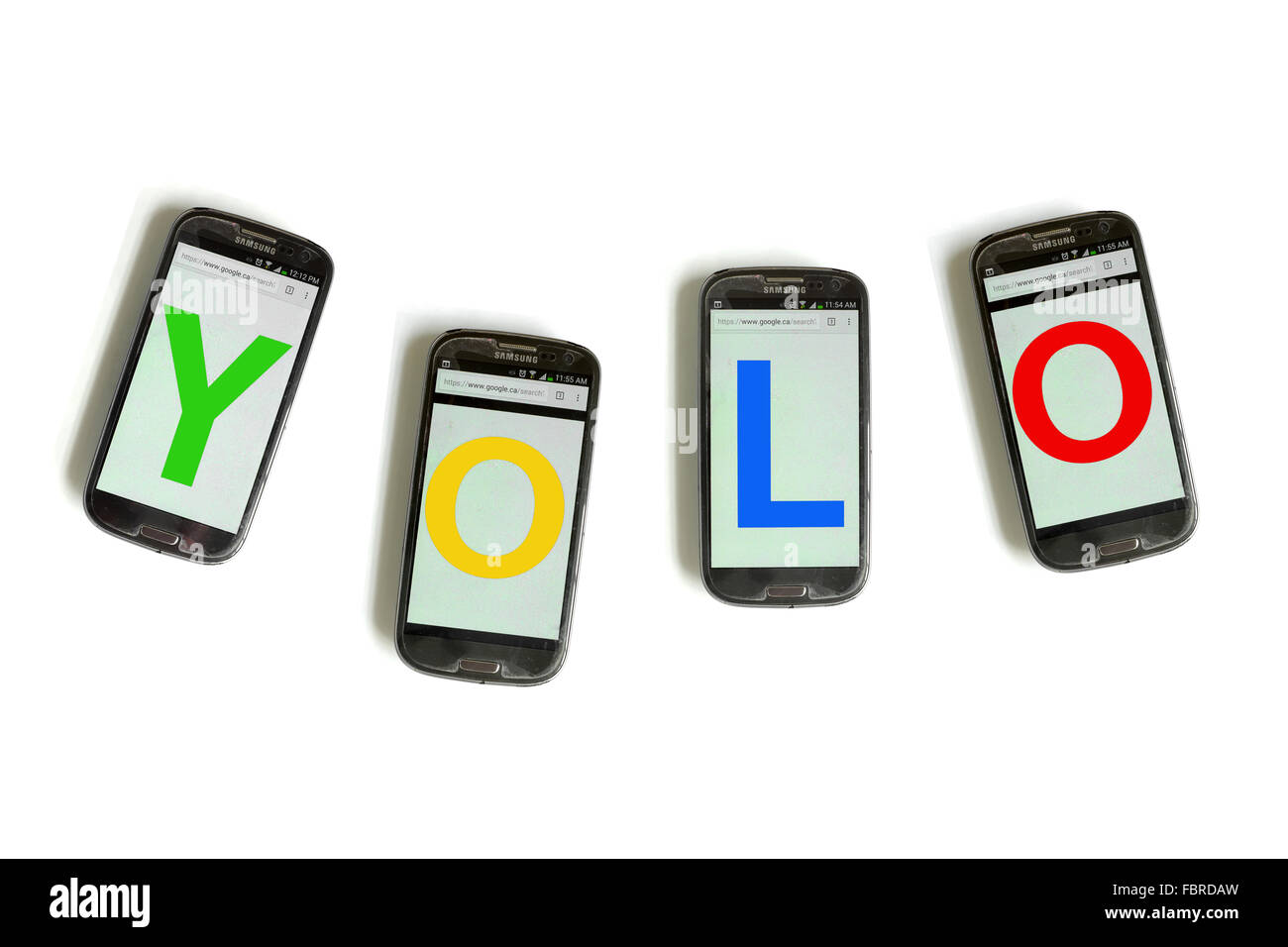 Yolo written on the screens of smartphones photographed against a white ...