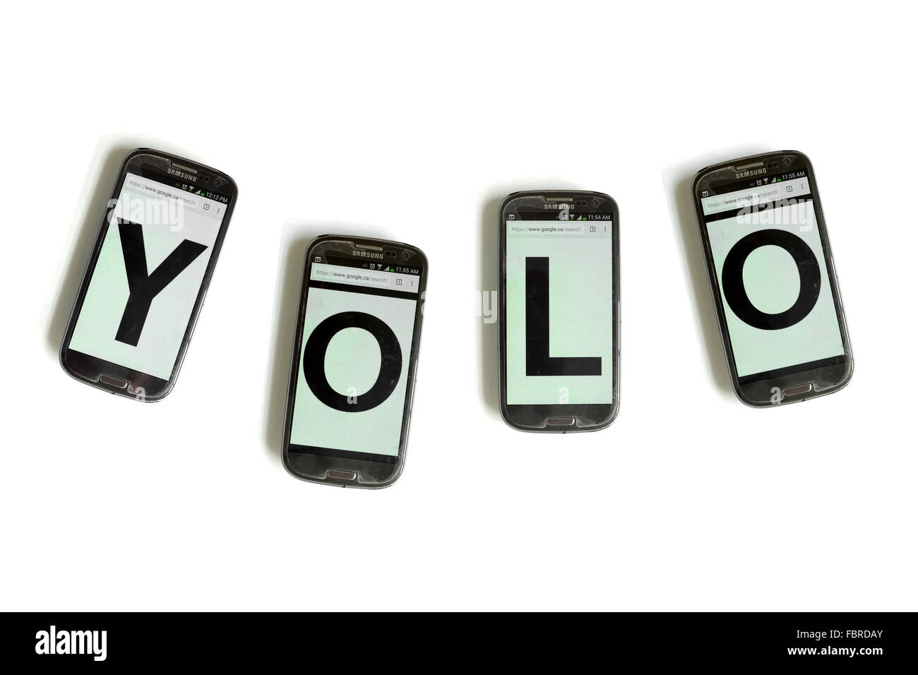 Yolo written on the screens of smartphones photographed against a white ...