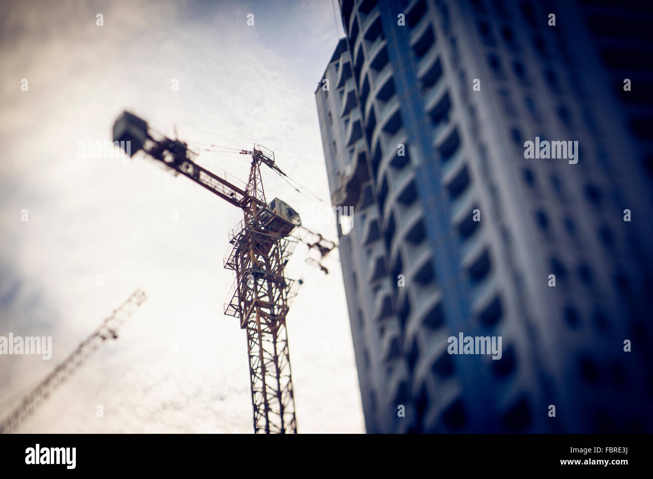 Abstract photo of building under construction with crane attached to ...
