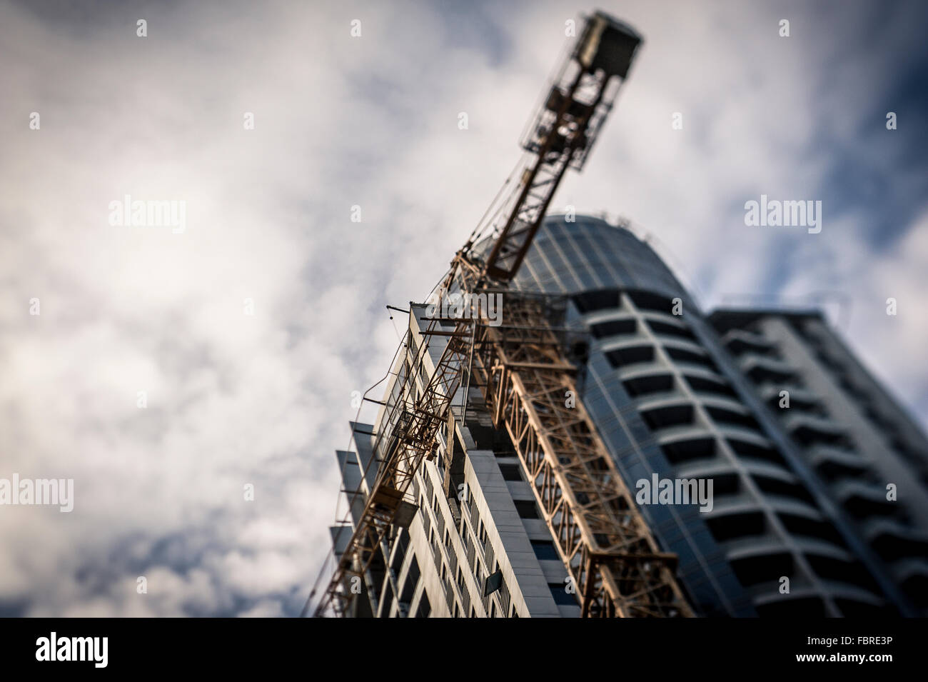 Abstract photo of building under construction with crane attached to ...
