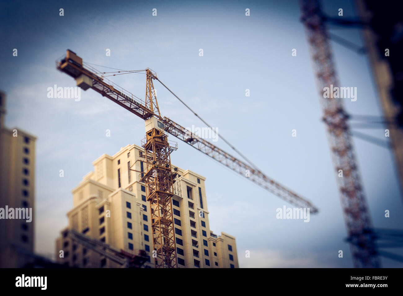 Abstract photo of building under construction with crane attached to ...