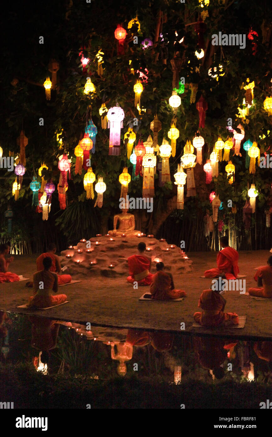 Chiang Mai, Thailand, 2016. Monks in saffron robes sitting under tree ...