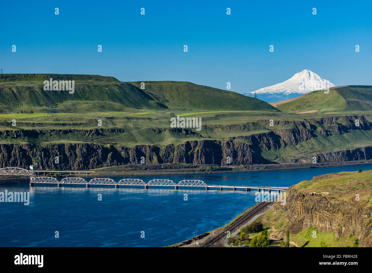 View of Mount Hood with a railroad bridge crossing the Columbia RIver ...