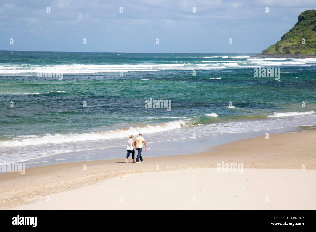 Couple walking Lennox Head and Seven Mile Beach on the north coast of ...