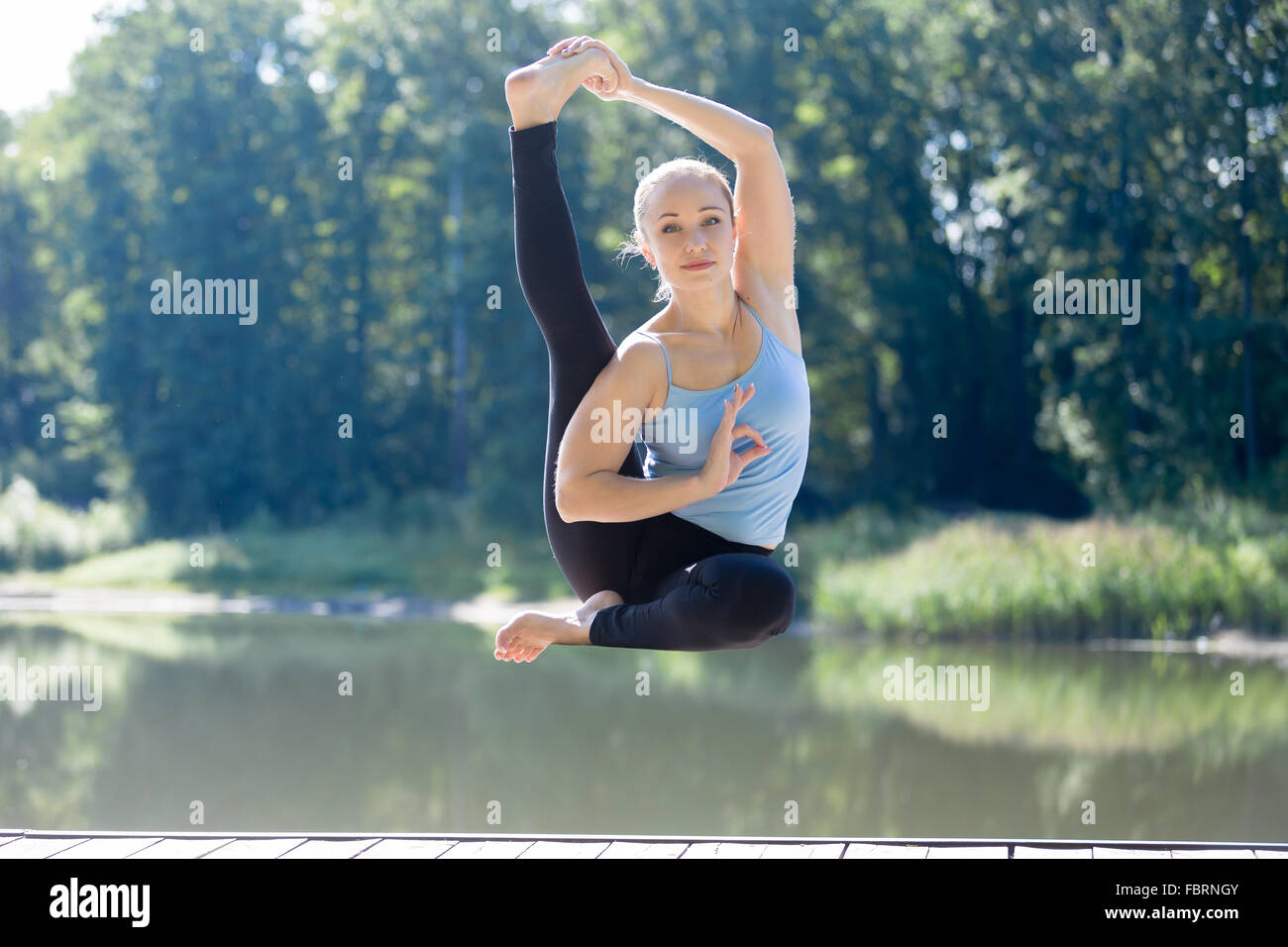 Portrait of serene young beautiful woman floating in midair during yoga ...