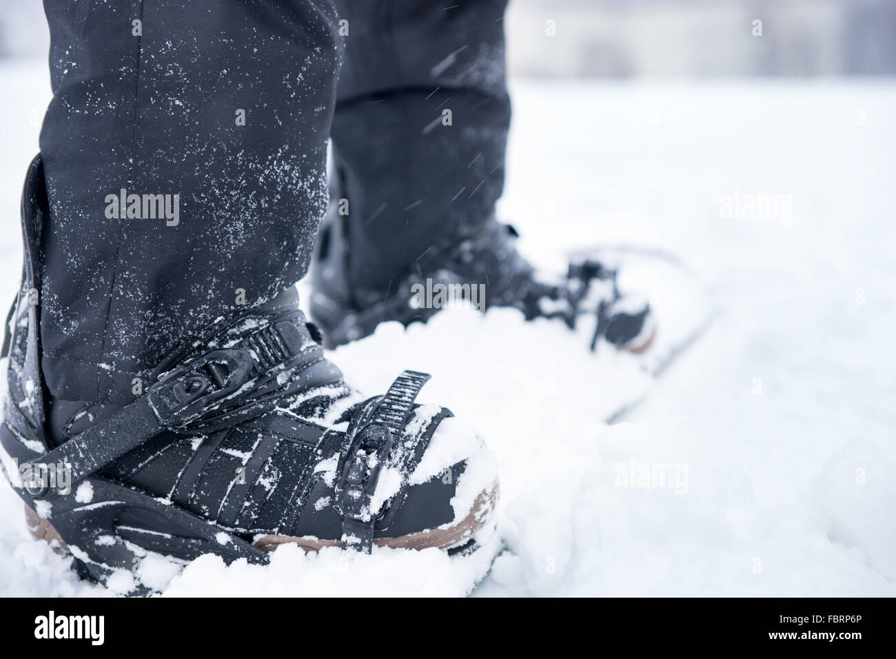 Close up of snowboard with latches connecting the skiers feet and ankle ...