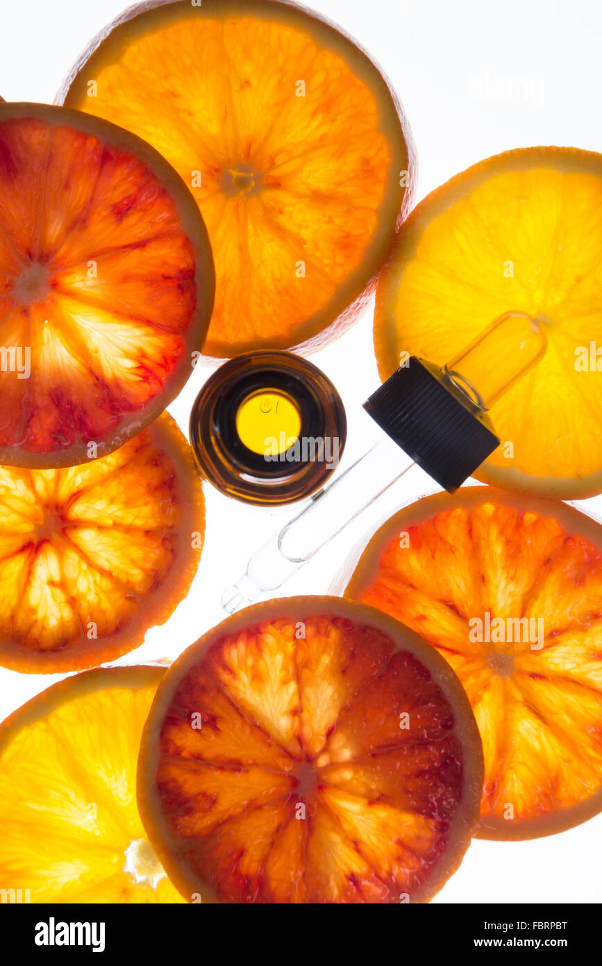 Orange essential oil with amber bottle with fresh blood orange slices ...