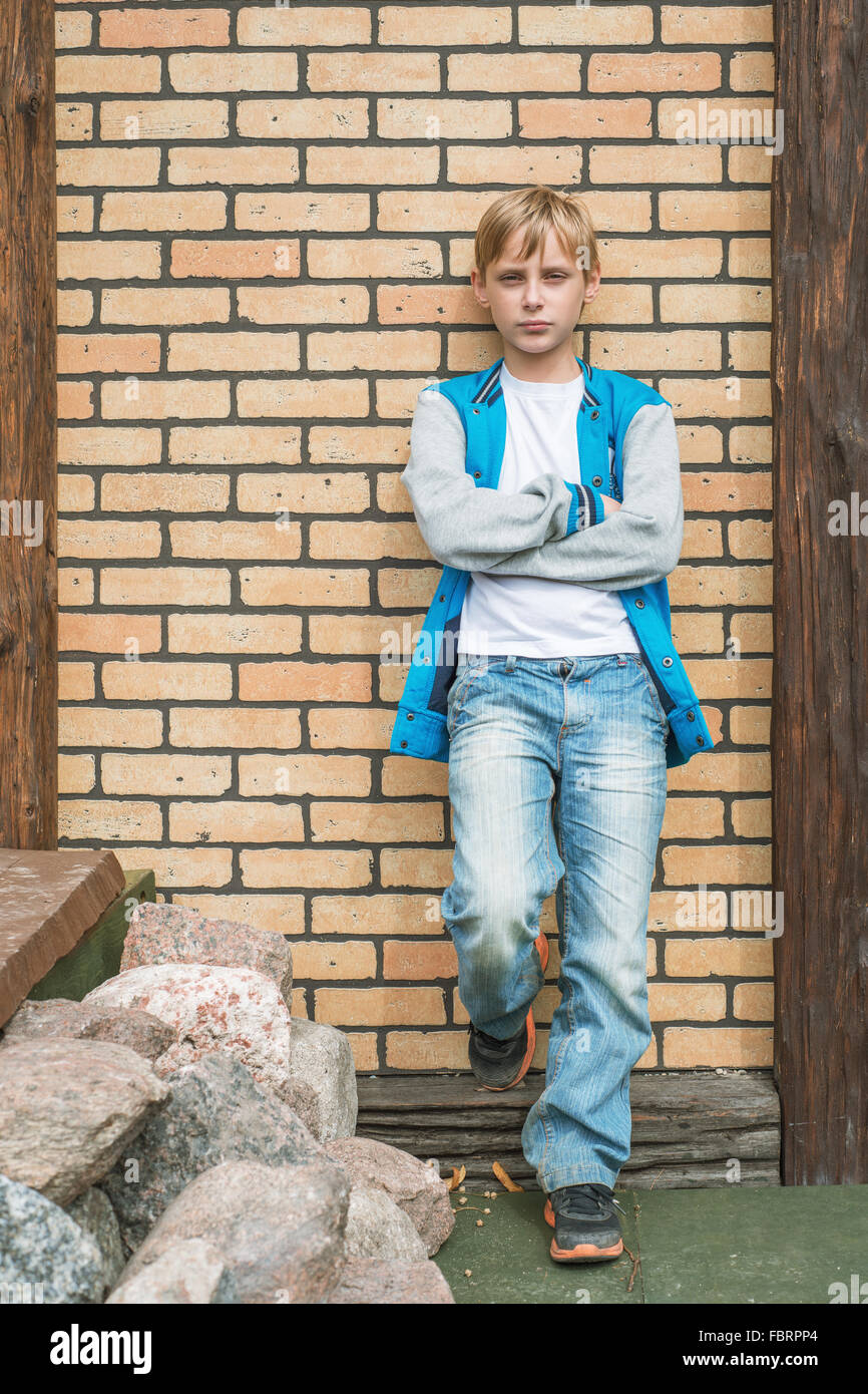 Boy stands near the brick wall Stock Photo - Alamy