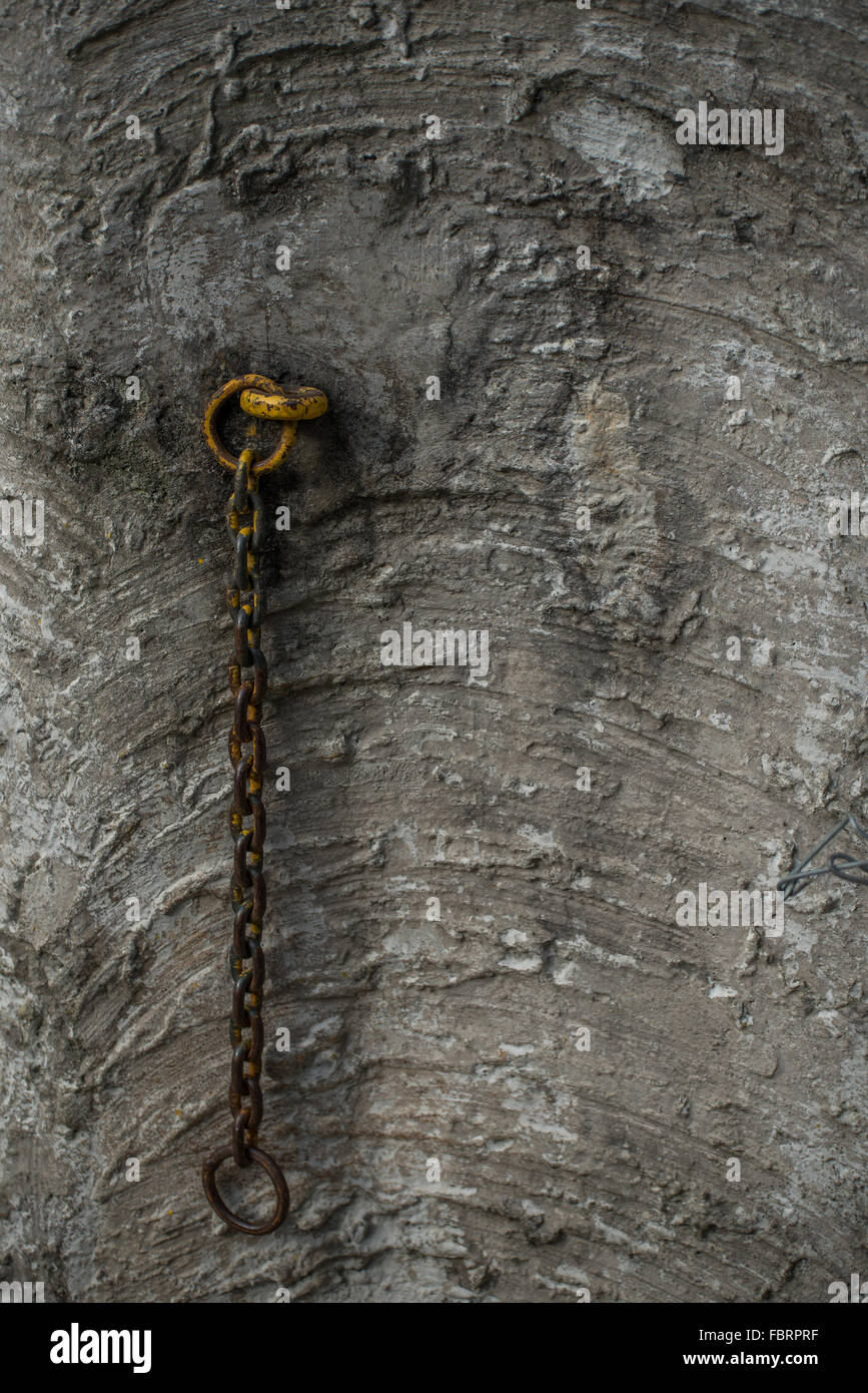 Rusty chain hanging from a textured tarnished wall. A lot like an ...