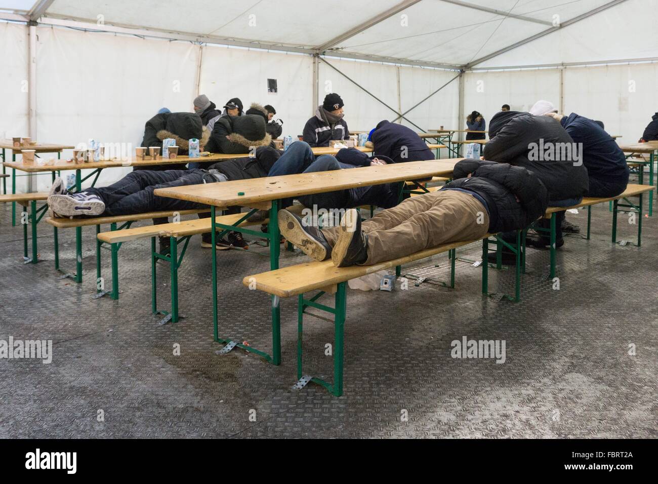 Refugees wait in a tent at the Central Registration Office for Asylum ...