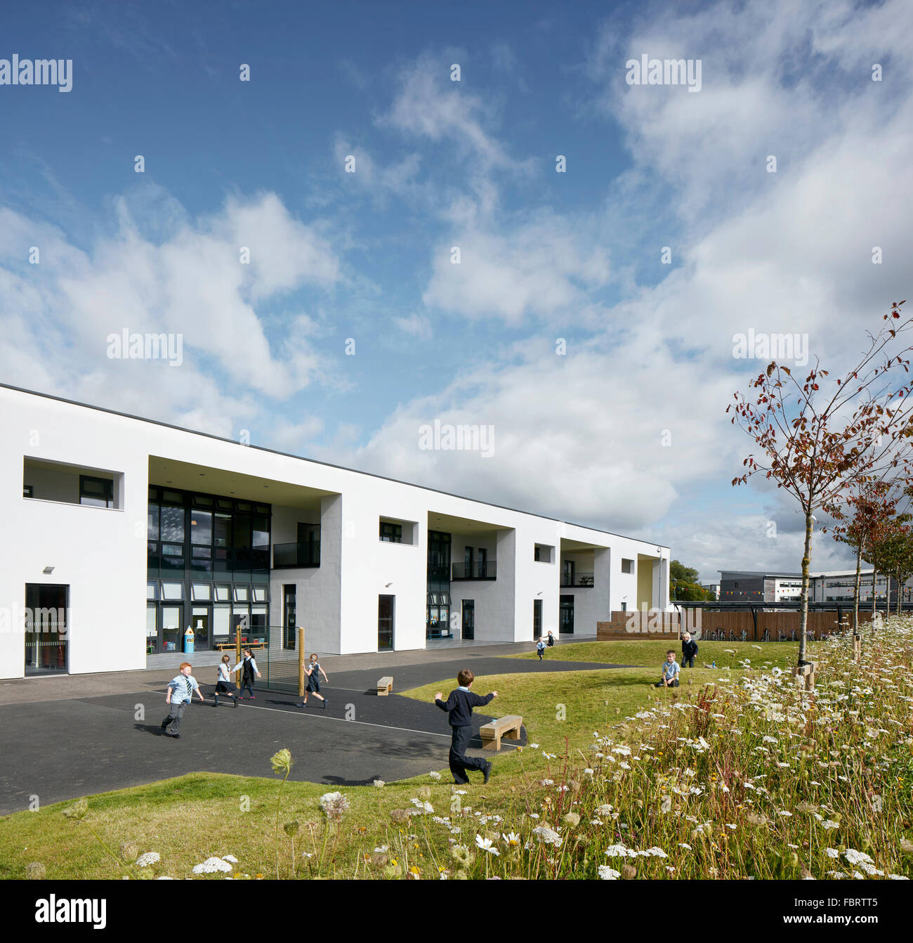 Building perspective with school grounds and children at play ...