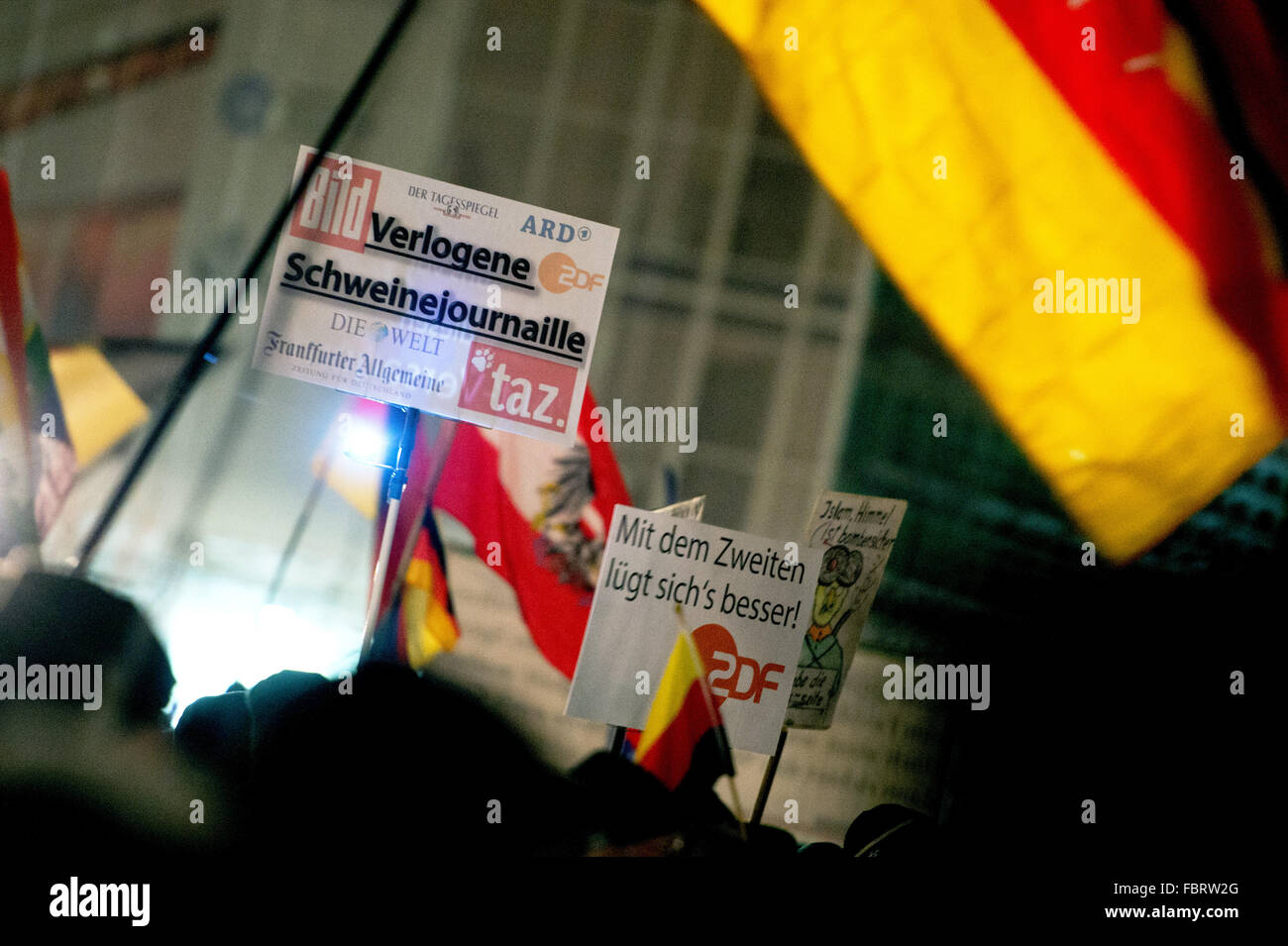 Dresden, Germany. 18th Jan, 2016. Demonstrators hold up flags and signs ...