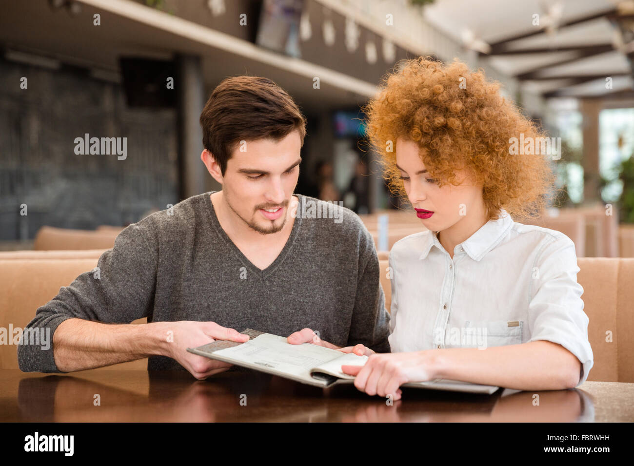 Portrait of a beautiful couple reading menu in restaurant Stock Photo ...