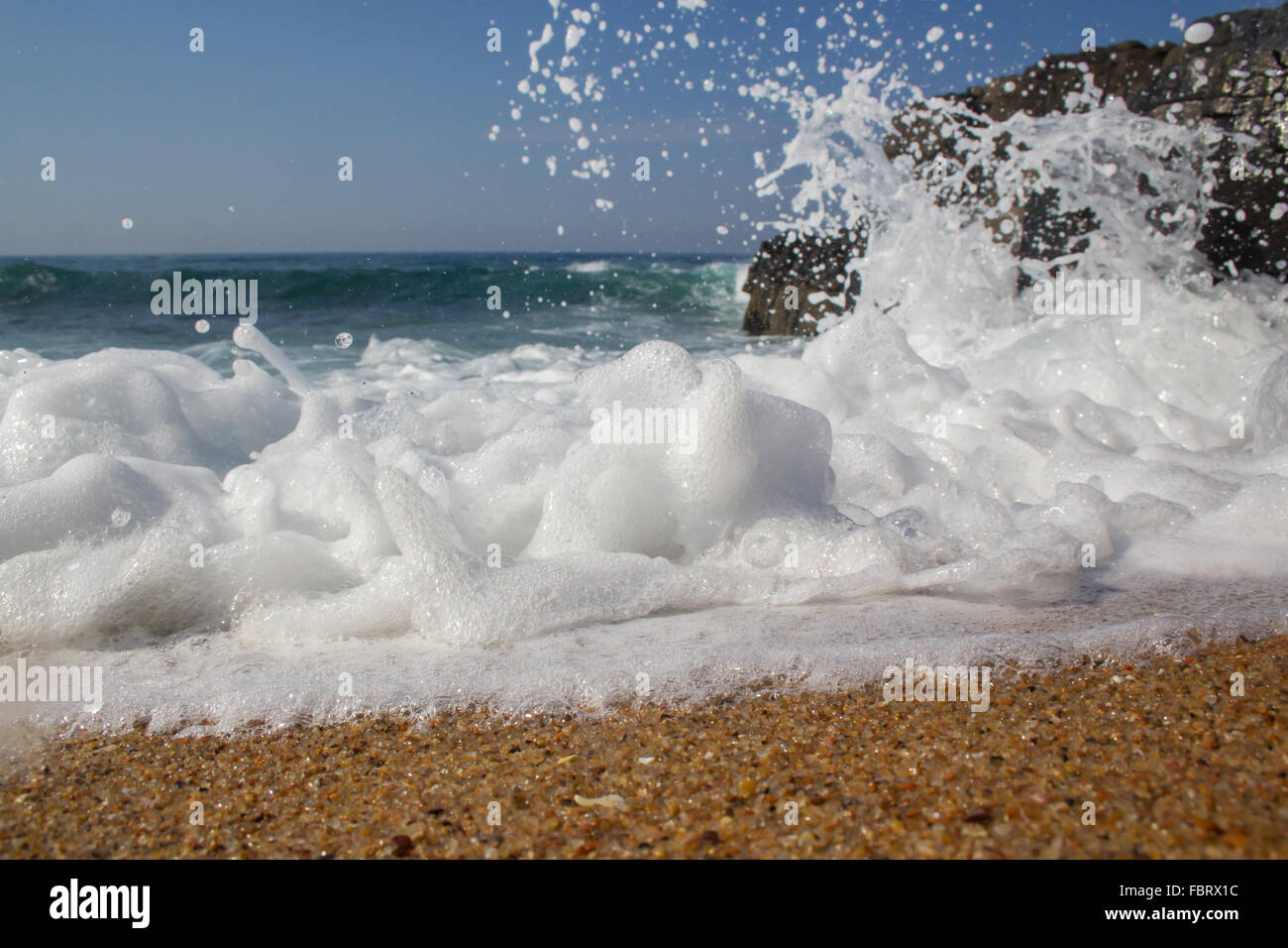 A low angle close up of a wave crashing onto the beach Stock Photo - Alamy