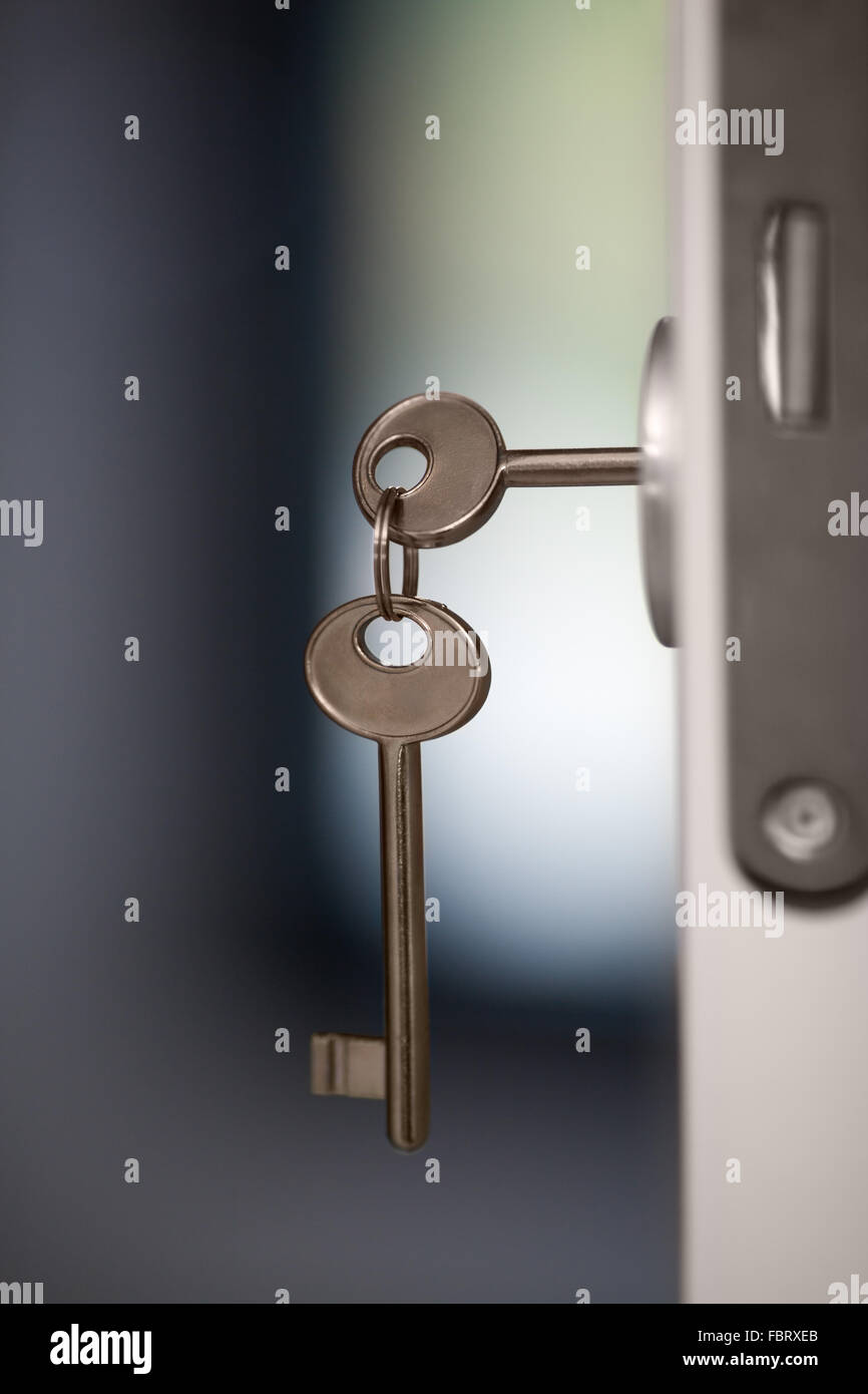 Close-up shot of keys in the lock of open door. One key is in lock ...