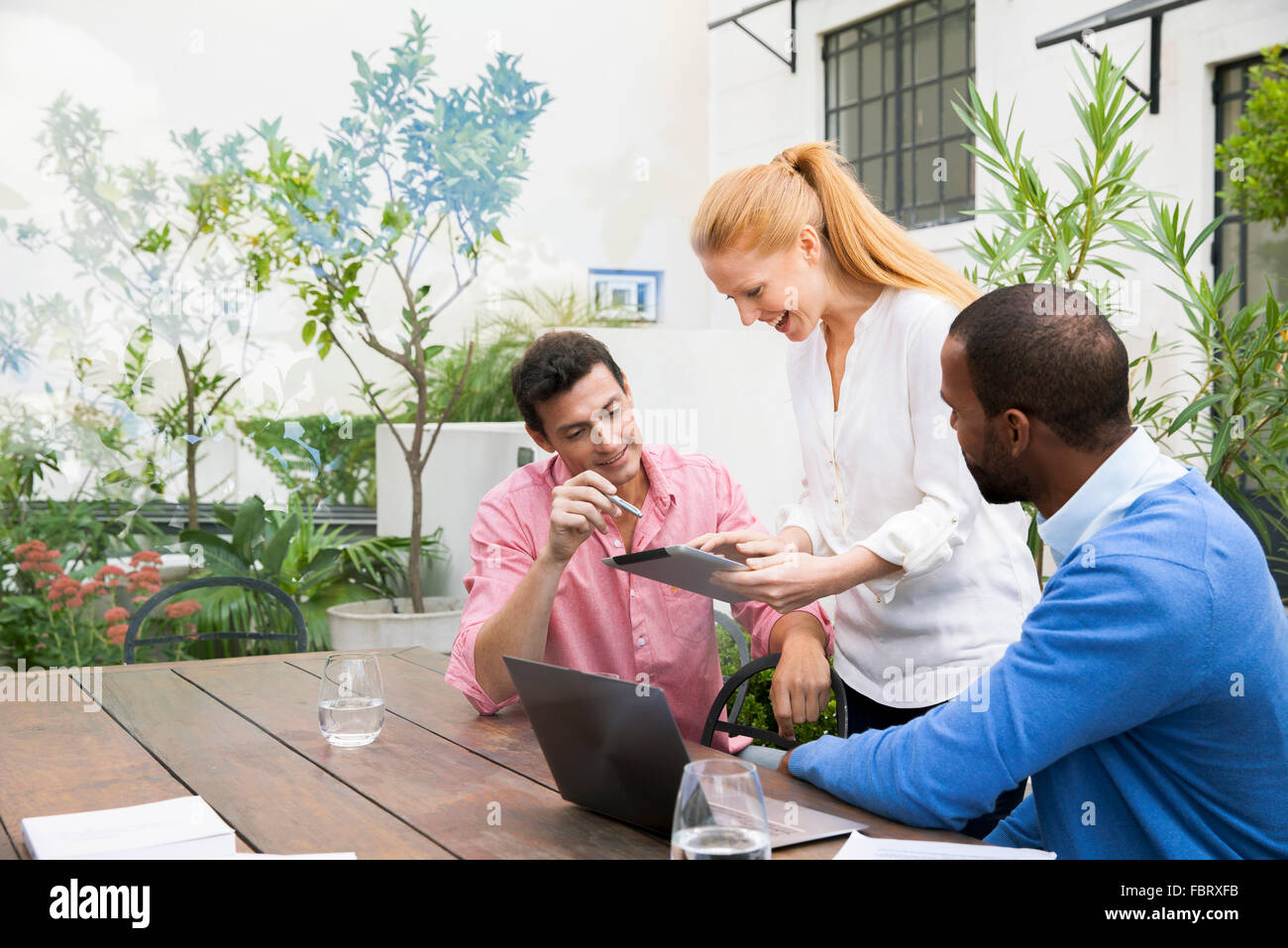 Businesswoman using digital tablet to present ideas to team members ...