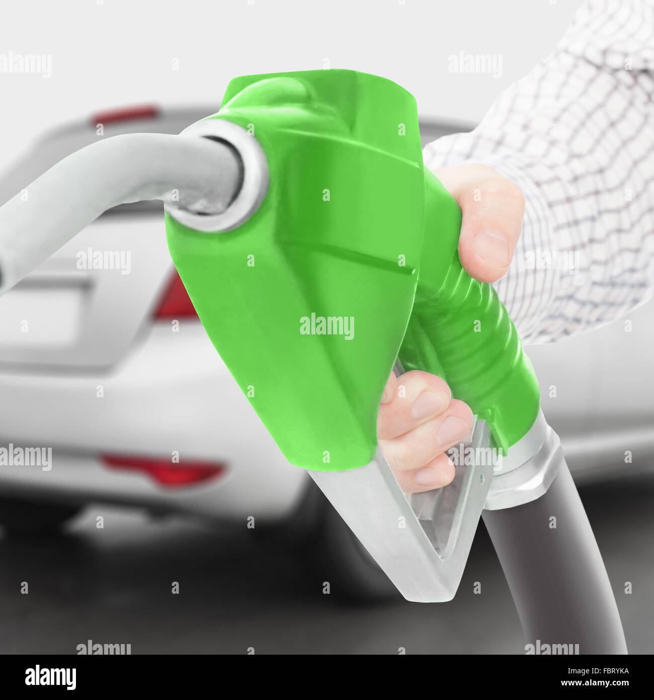 Green color fuel pump gun in hand with car on background - studio shot ...
