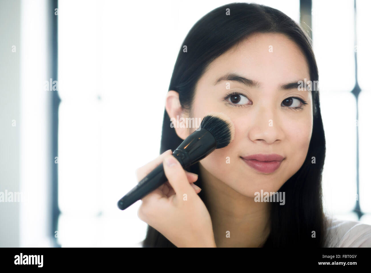 Woman applying blush Stock Photo - Alamy